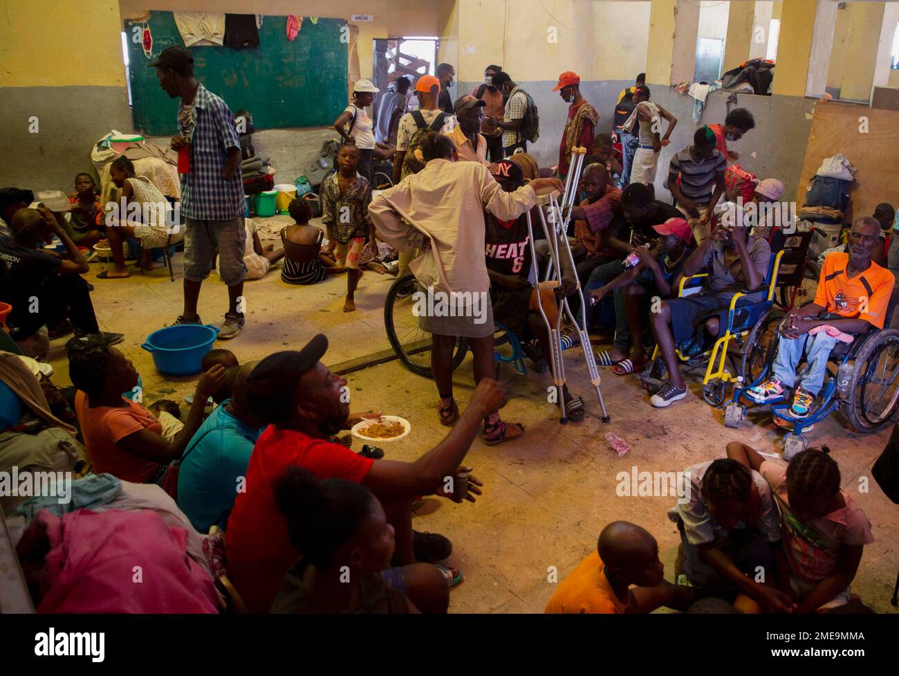 A group of blind and disabled people eat at a refuge for displaced ...
