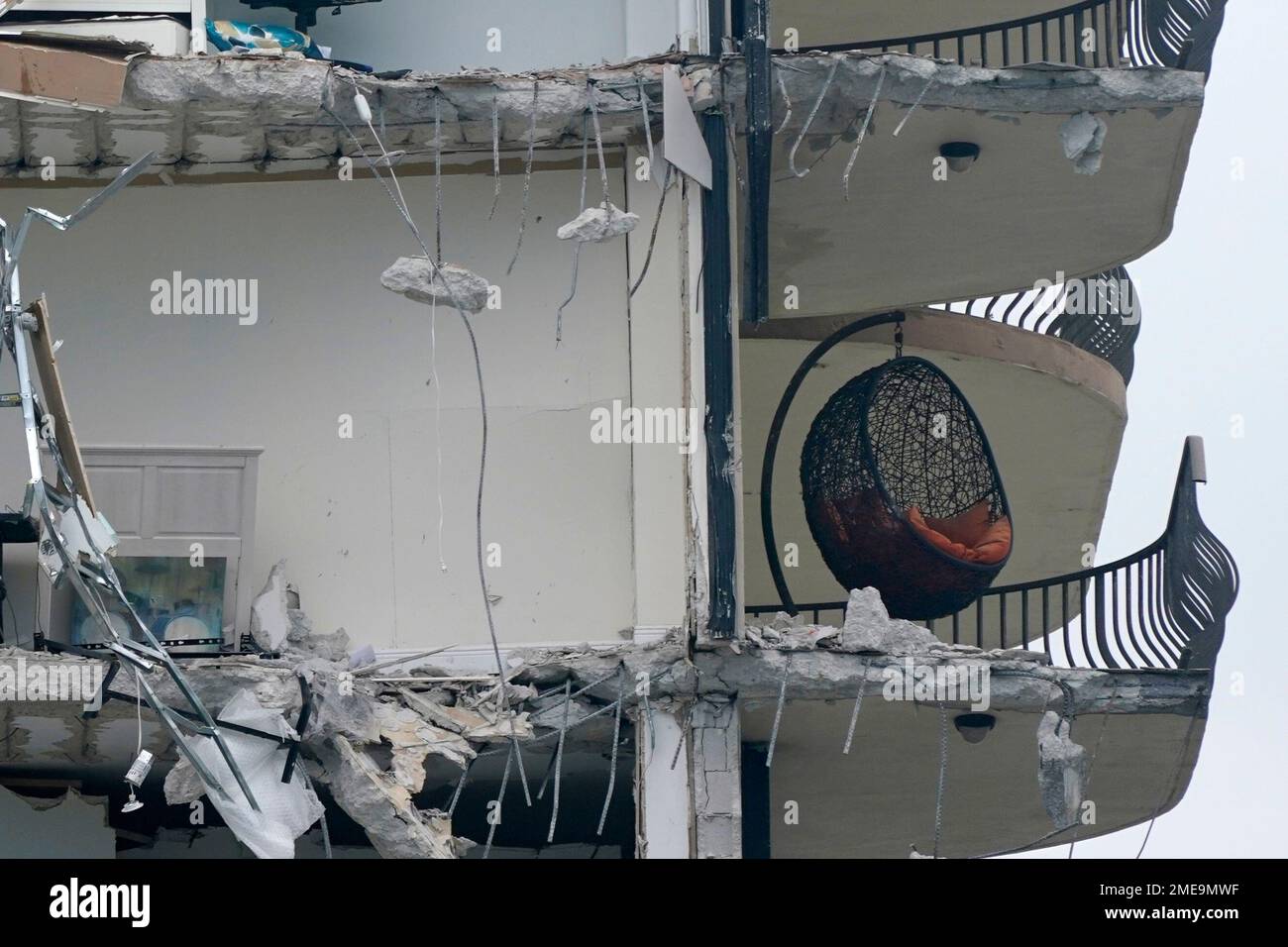 A hanging chair sits on what is left of a balcony on a building that ...