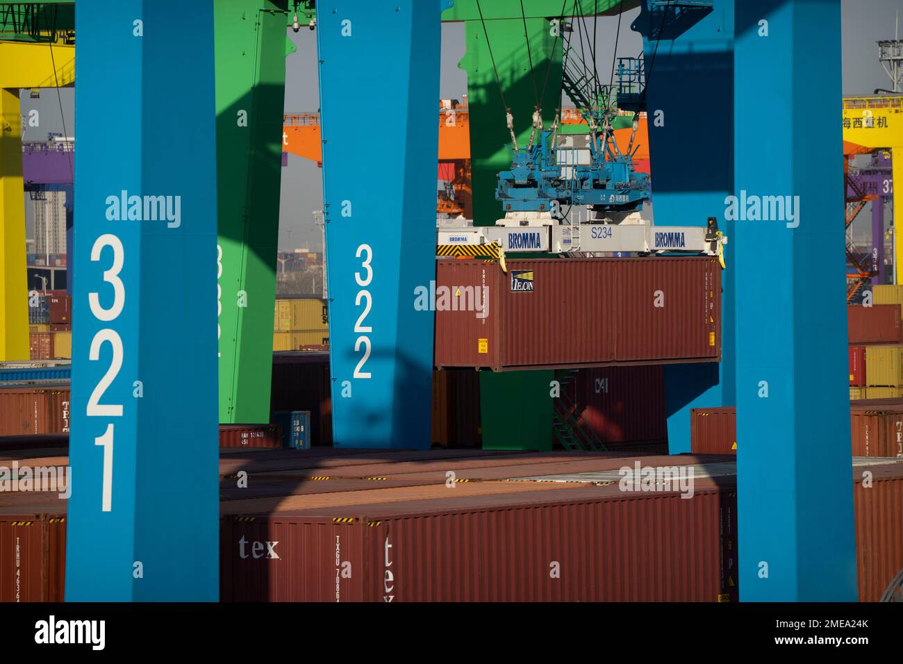 An automated crane picks up a shipping container onto a freighter at a ...