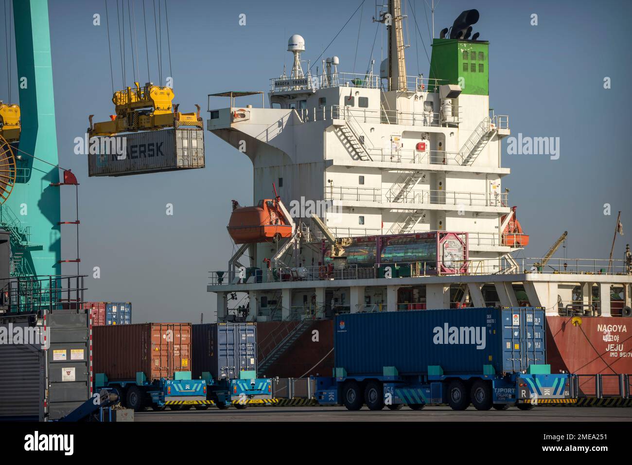 An automated crane loads a shipping container onto a freighter at a ...