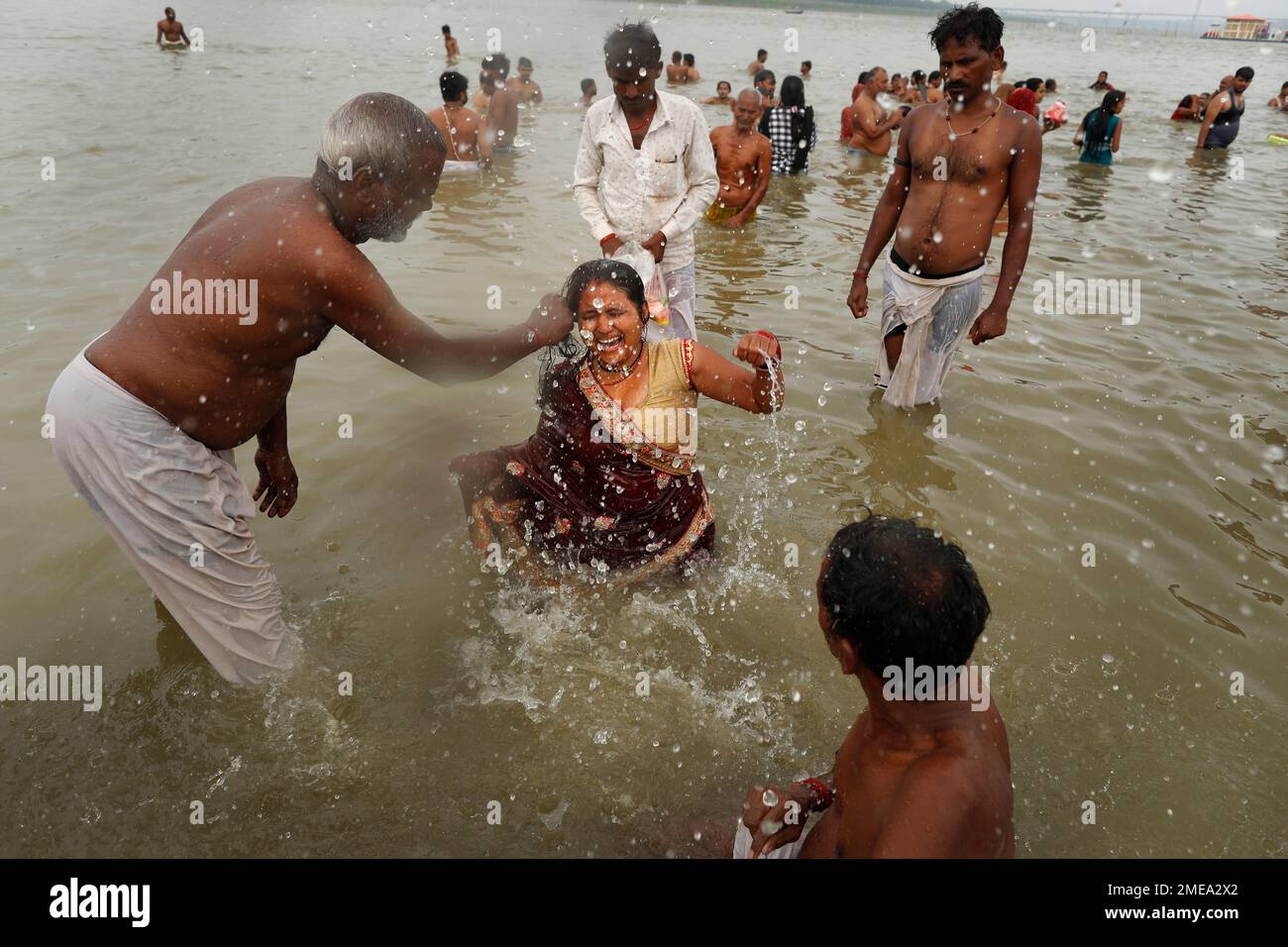 A priest performs exorcism on a Hindu devotee by immersing her in the ...