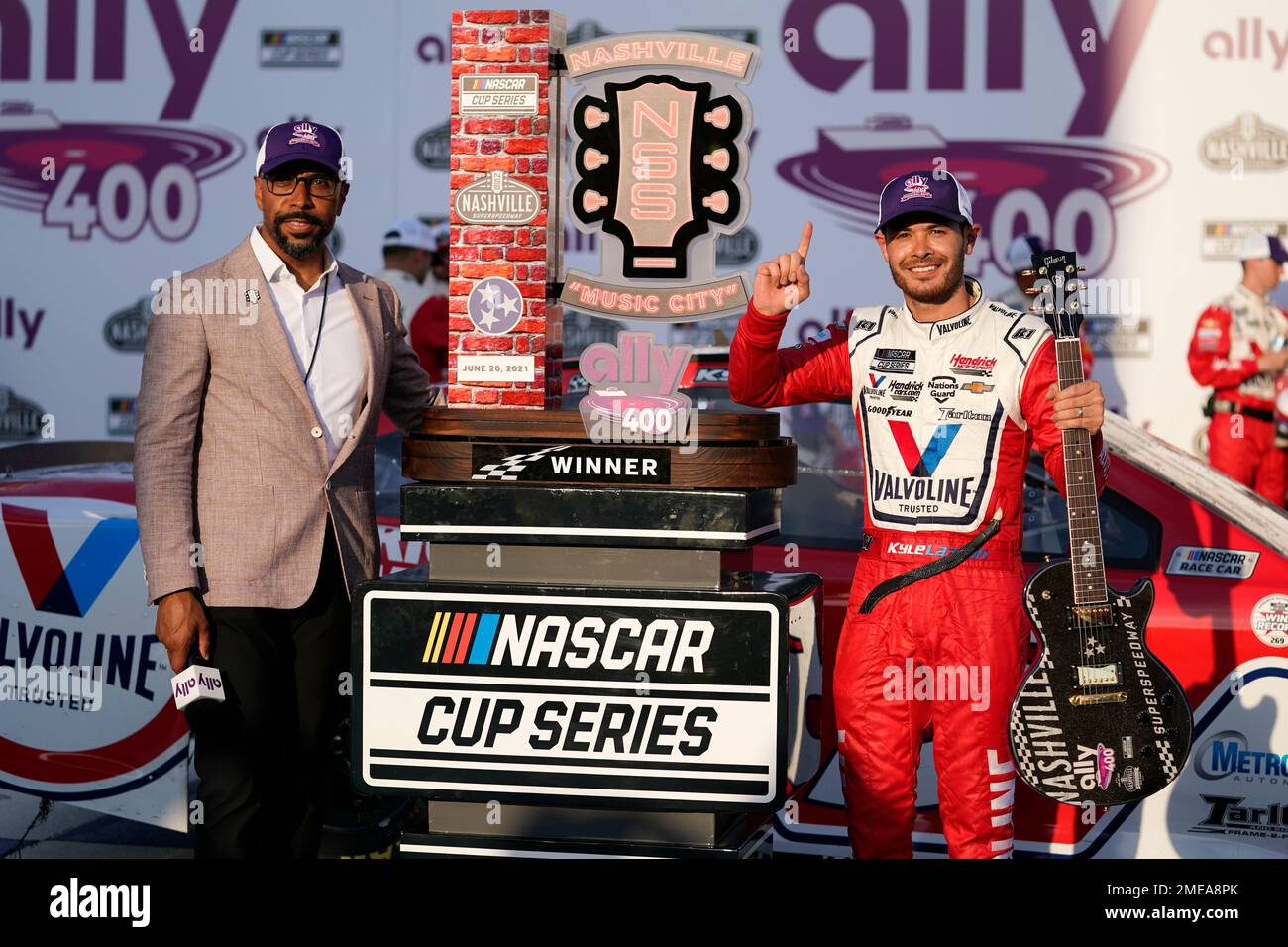 Kyle Larson celebrates with the winner's guitar and trophy presented to ...