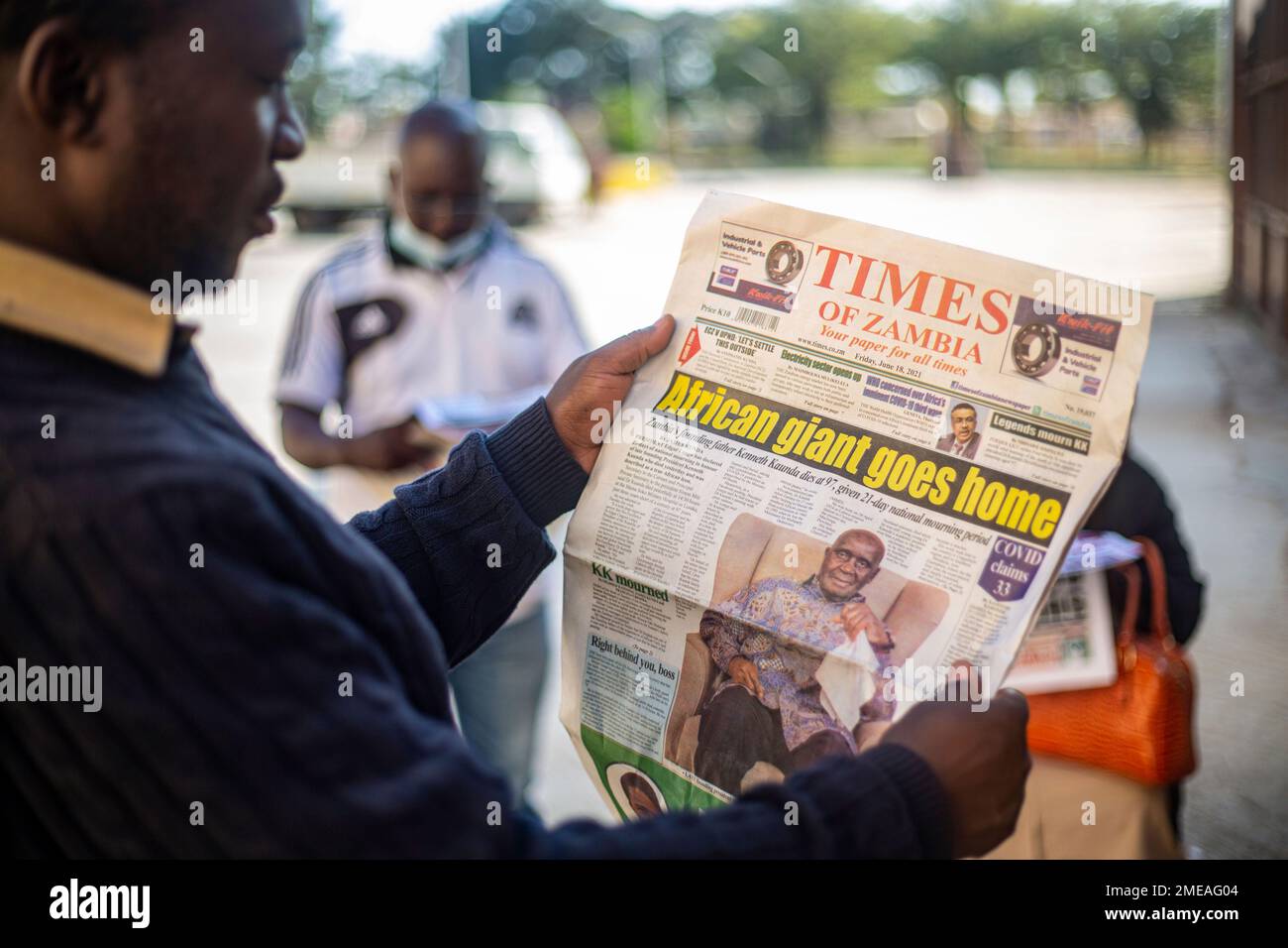 A man poses with a newspaper front page in Lusaka, Zambia, Friday, July ...