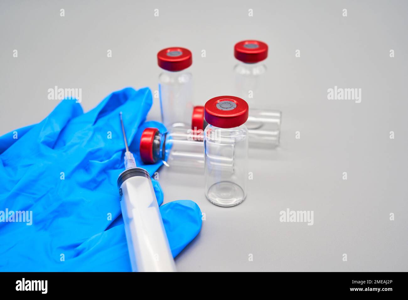 Medical gloves and vials on grey background for needle injection ...