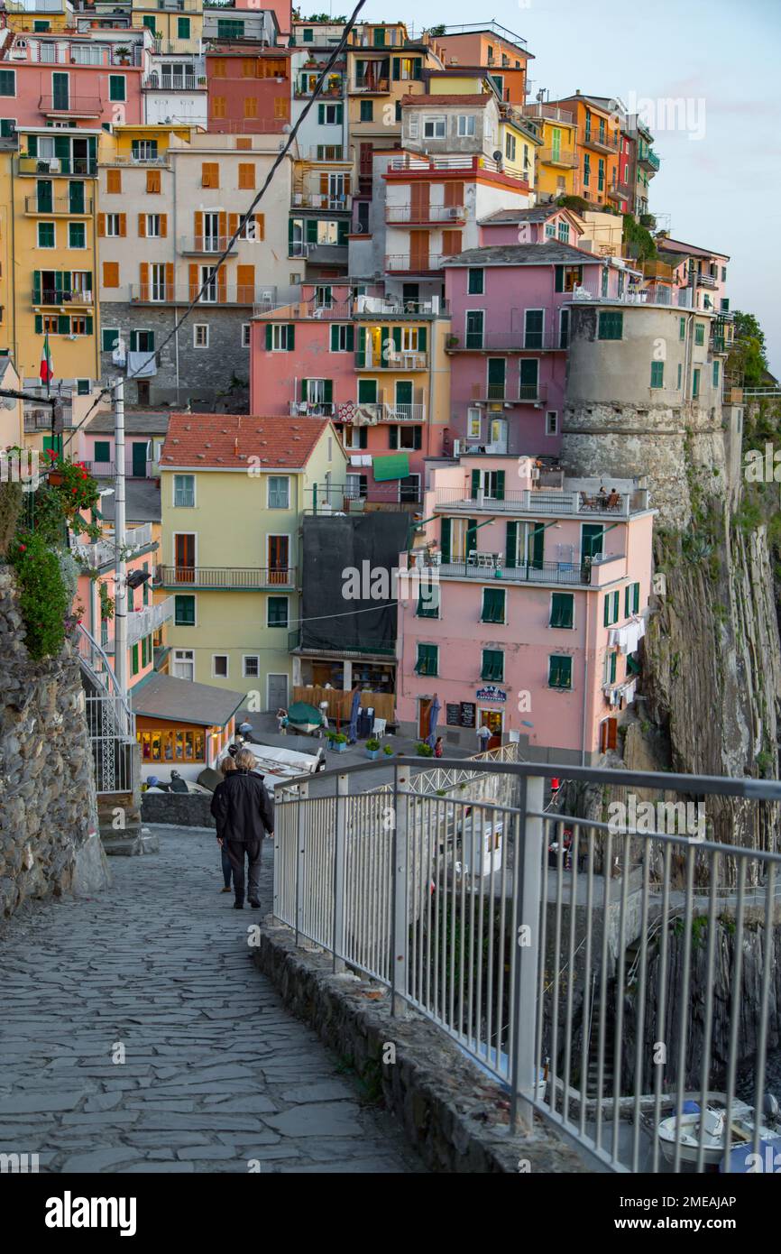 People walking towards colorful cliffside houses of Manarola, one the 5 ...