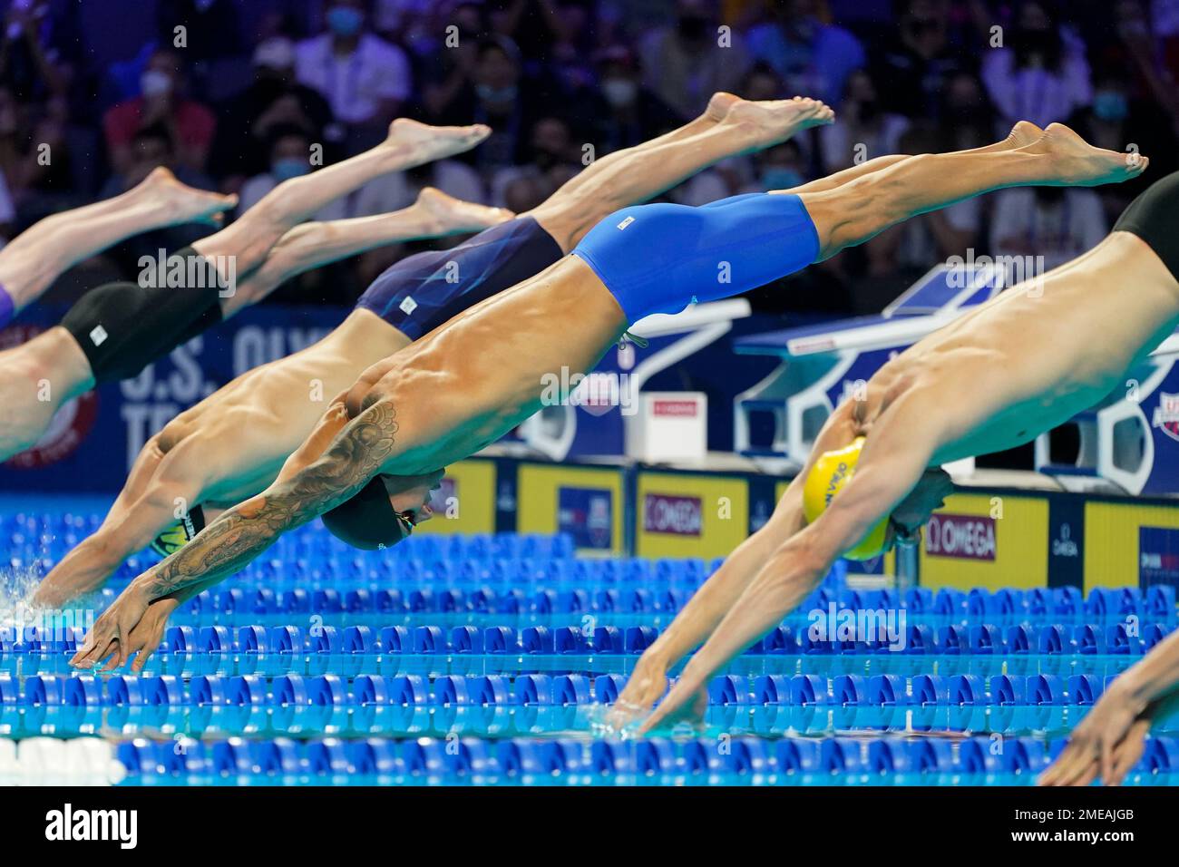 Caeleb Dressel, center, dives at the start of the men's 100-meter ...
