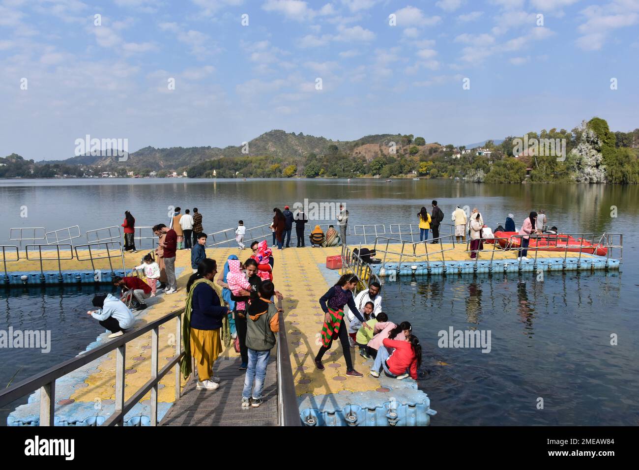 Visitors walk through the jetty as they explore the Mansar lake on a ...