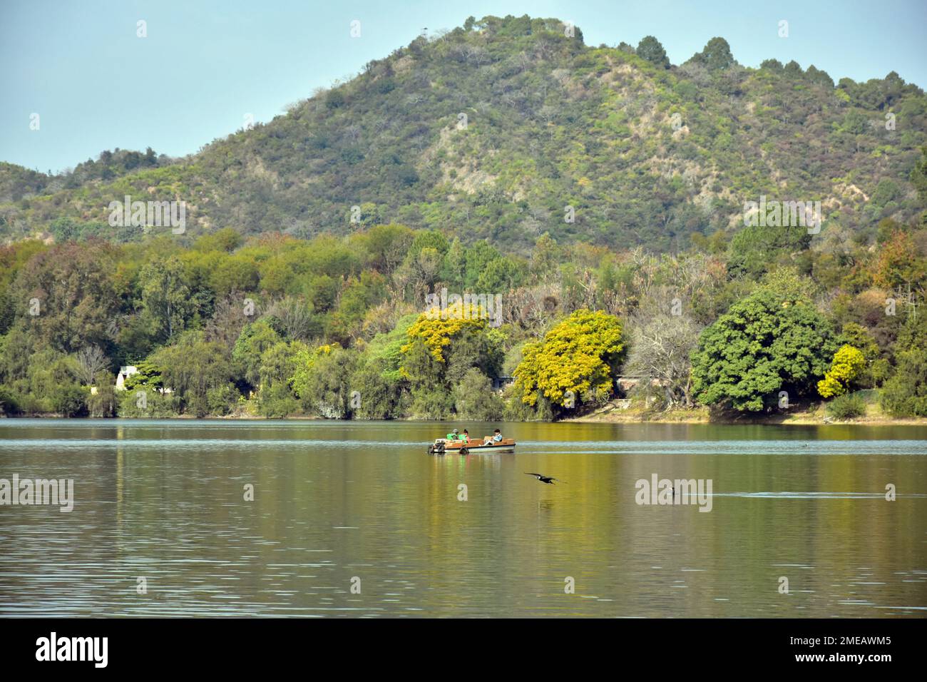 Visitors enjoy the boat ride across the Mansar lake on a sunny winter ...