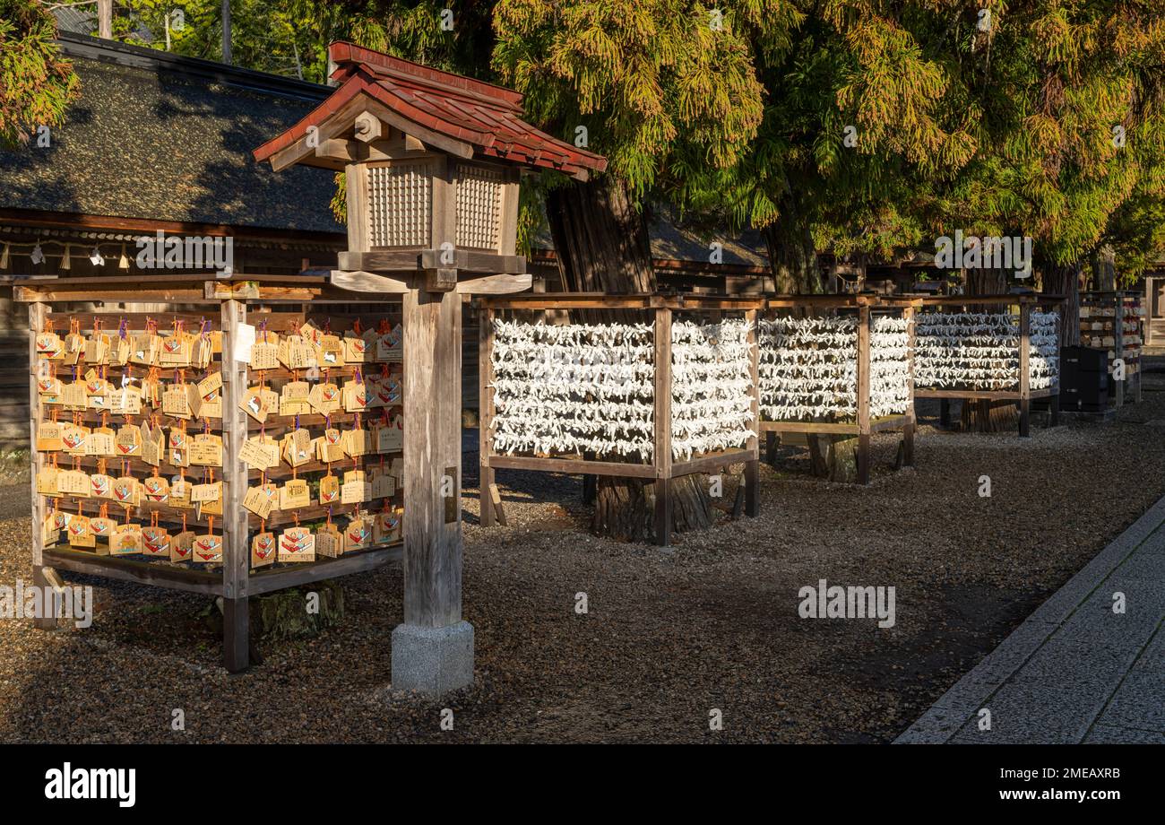 Wooden cards (ema) with prayers and wishes and white paper omikuji ...