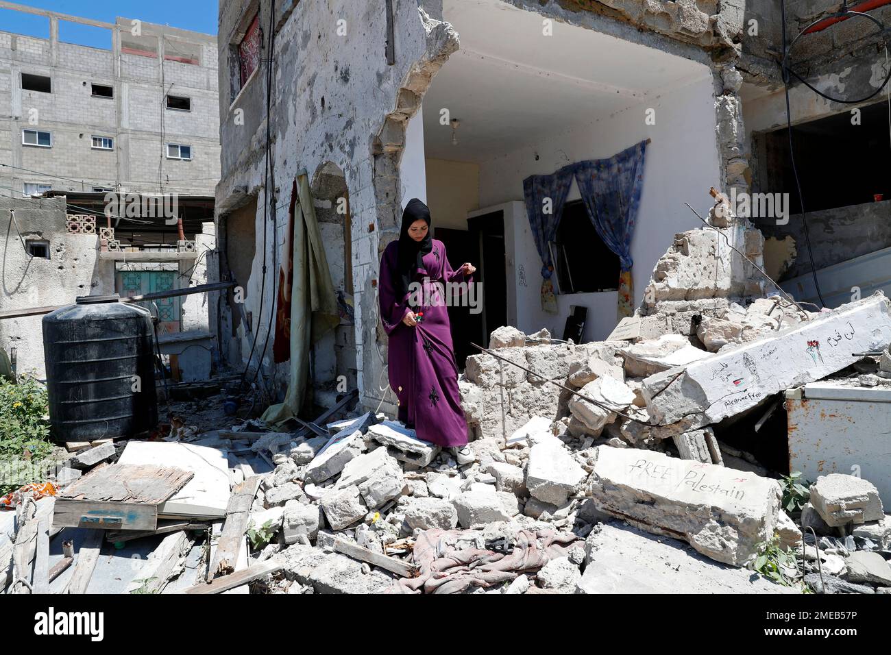 Artist Saja Moussa walks amid the rubble of her family's house in Rafah ...