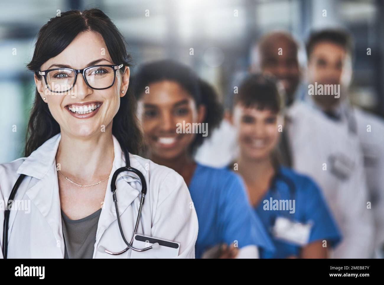 How can we help you feel better. Portrait of a diverse team of doctors standing together in a ...