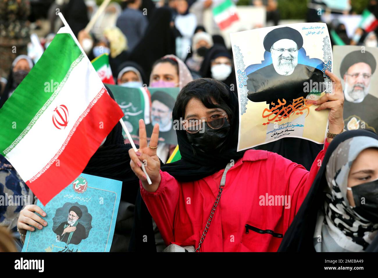 A supporter of presidential candidate Ebrahim Raisi holds up a picture ...