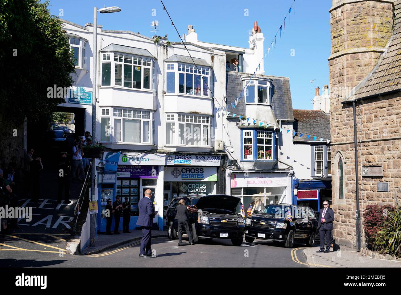 Motorcade vehicles wait outside Sacred Heart and St. Ia Catholic Church ...