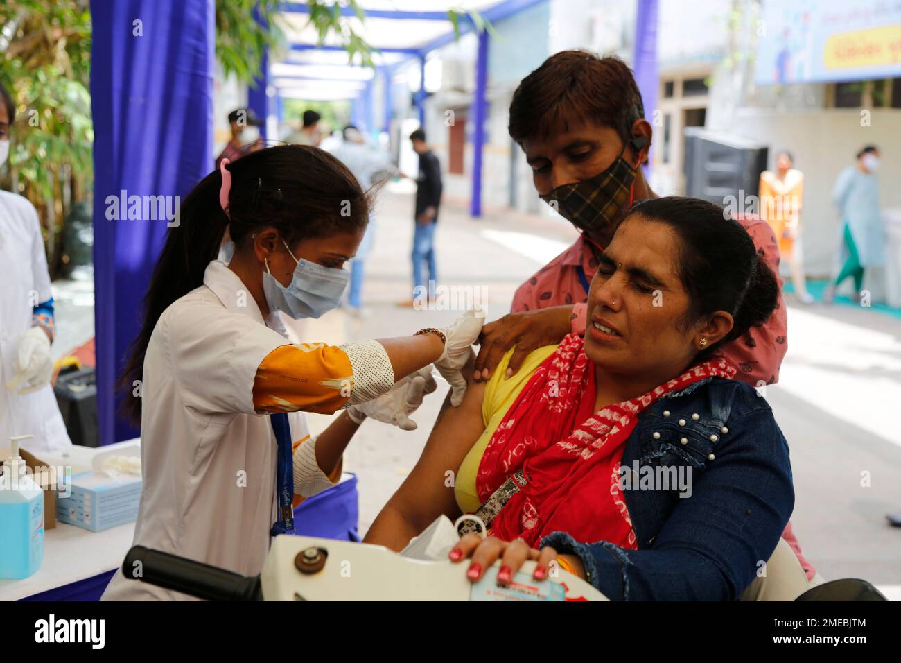 A physically disabled woman reacts as she gets a dose of Covishield ...