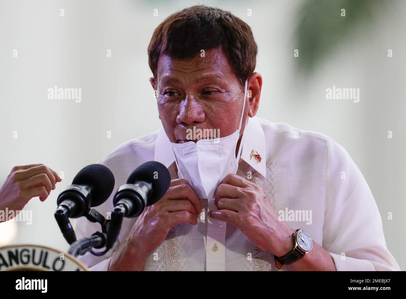 Philippine President Rodrigo Duterte removes his face mask before ...