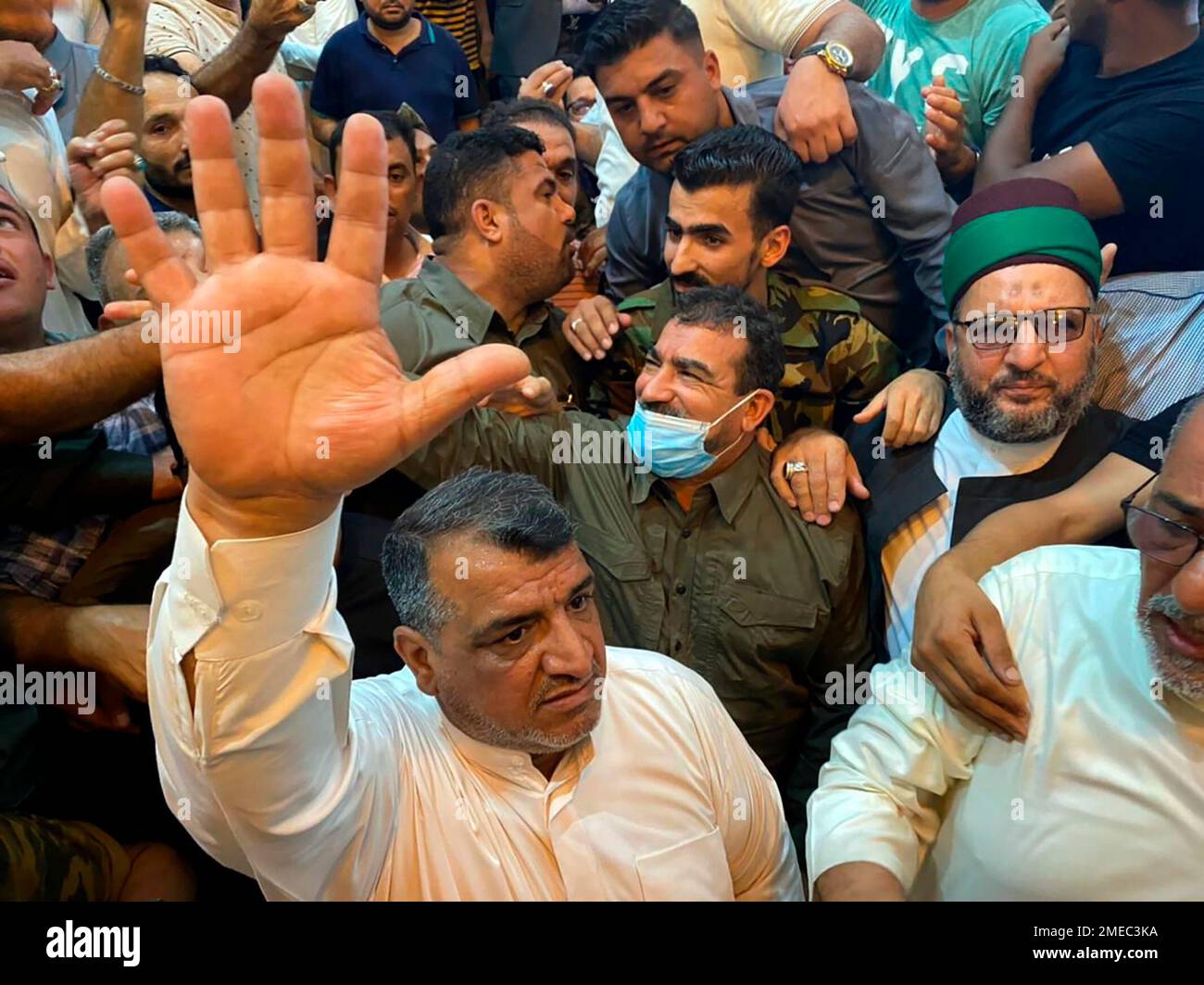 Qassim Mahmoud Musleh, center with mask, an Iraqi militia commander, is ...