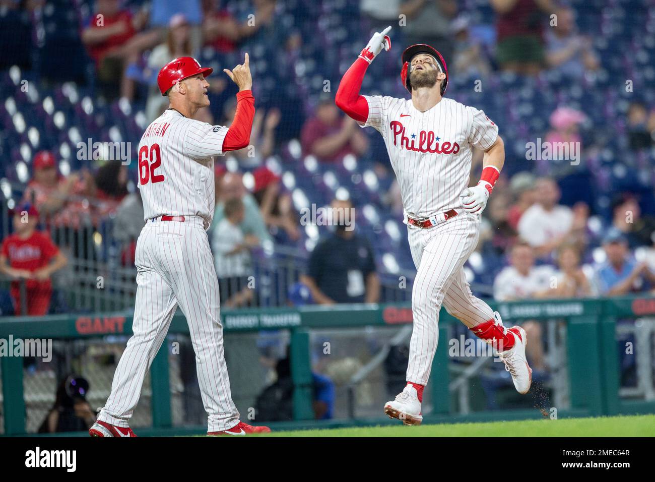 Philadelphia Phillies' Bryce Harper, right, gestures to the sky with ...