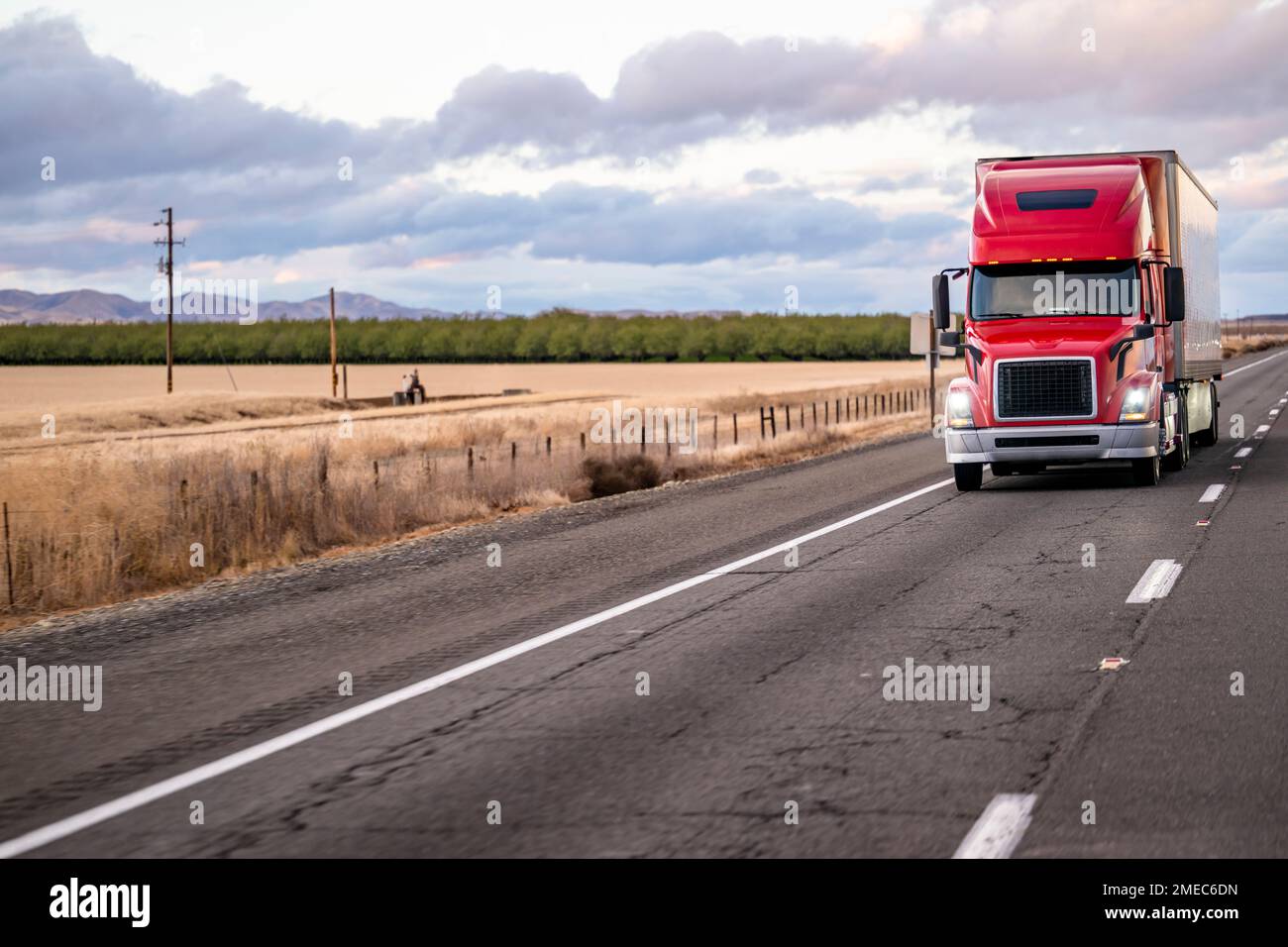 Industrial long hauler big rig red semi truck tractor with truck driver ...