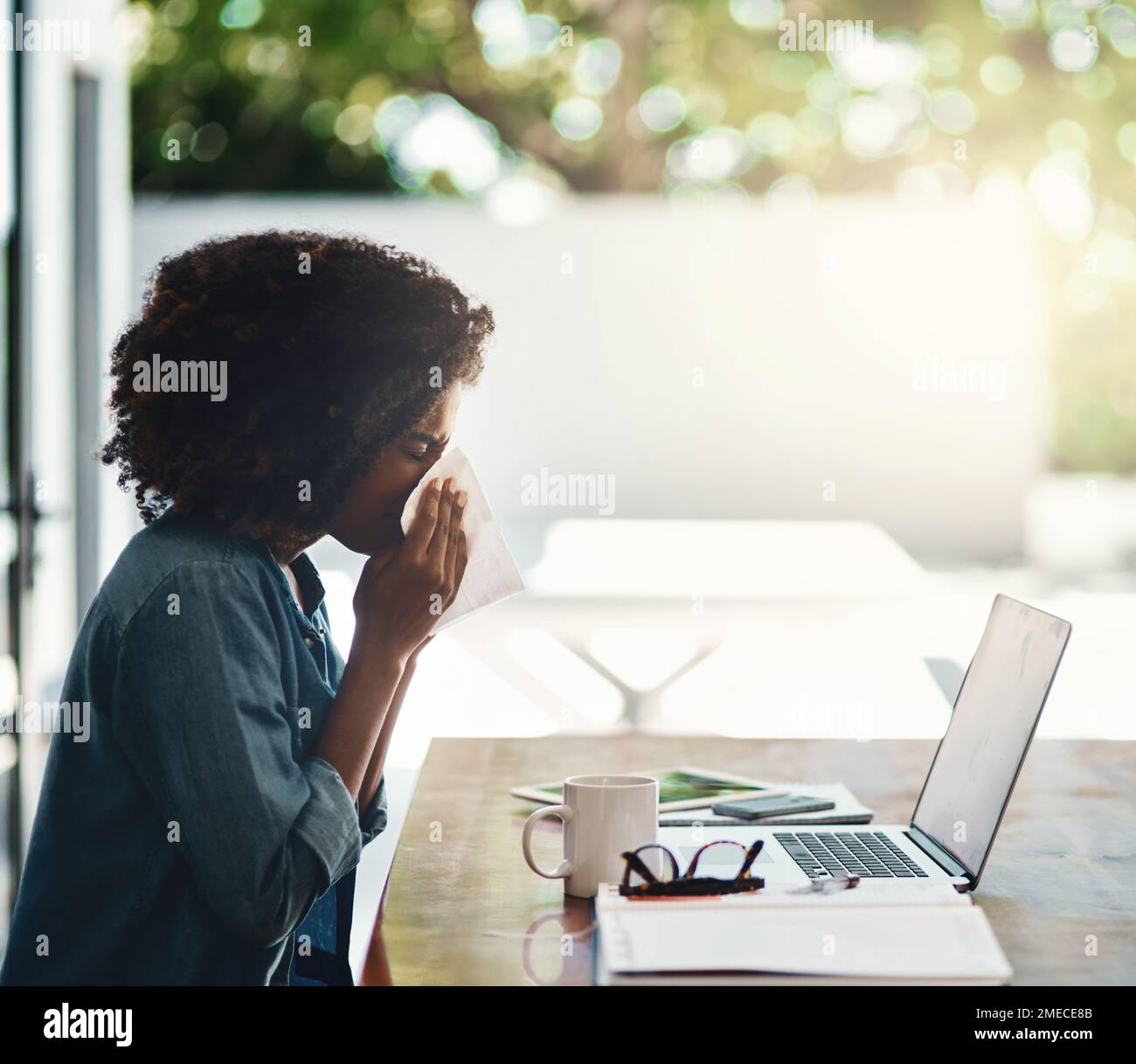Could this be the first signs of flu. a young woman blowing her nose ...