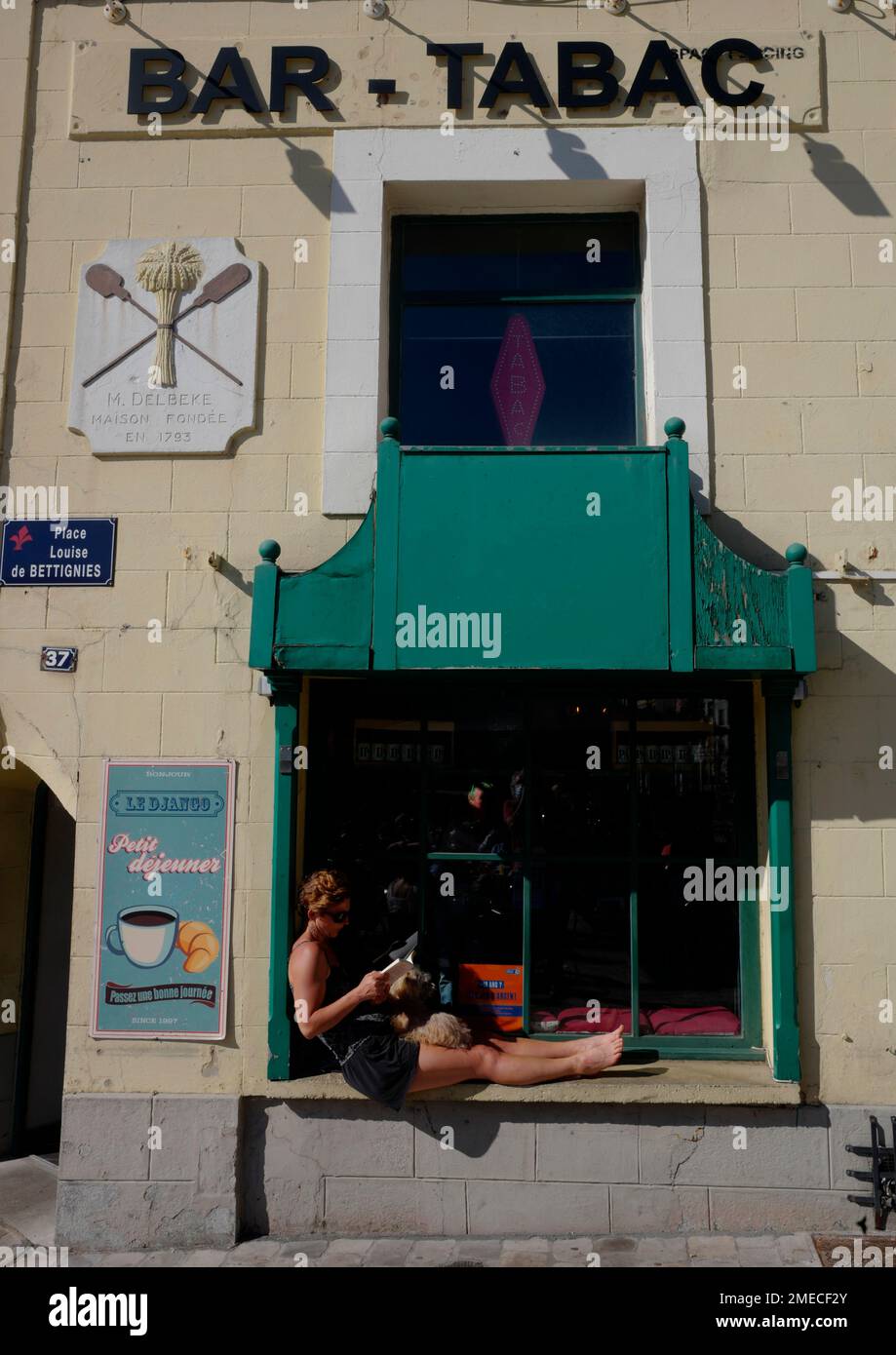 A women enjoys the sun at a cafe terrace in Lille, northern France ...