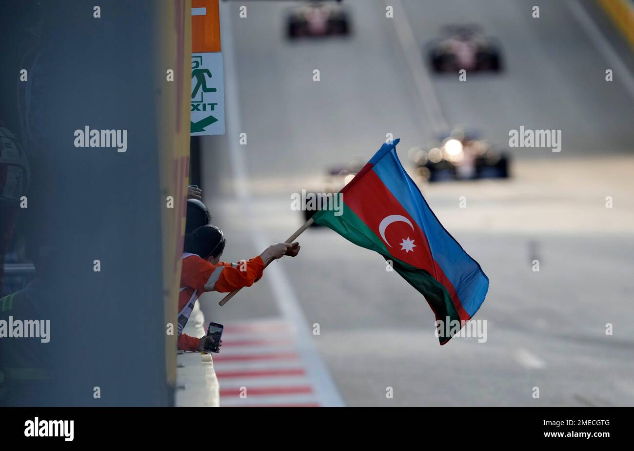 A track marshal waves the flag of Azerbaijan during the Formula One ...