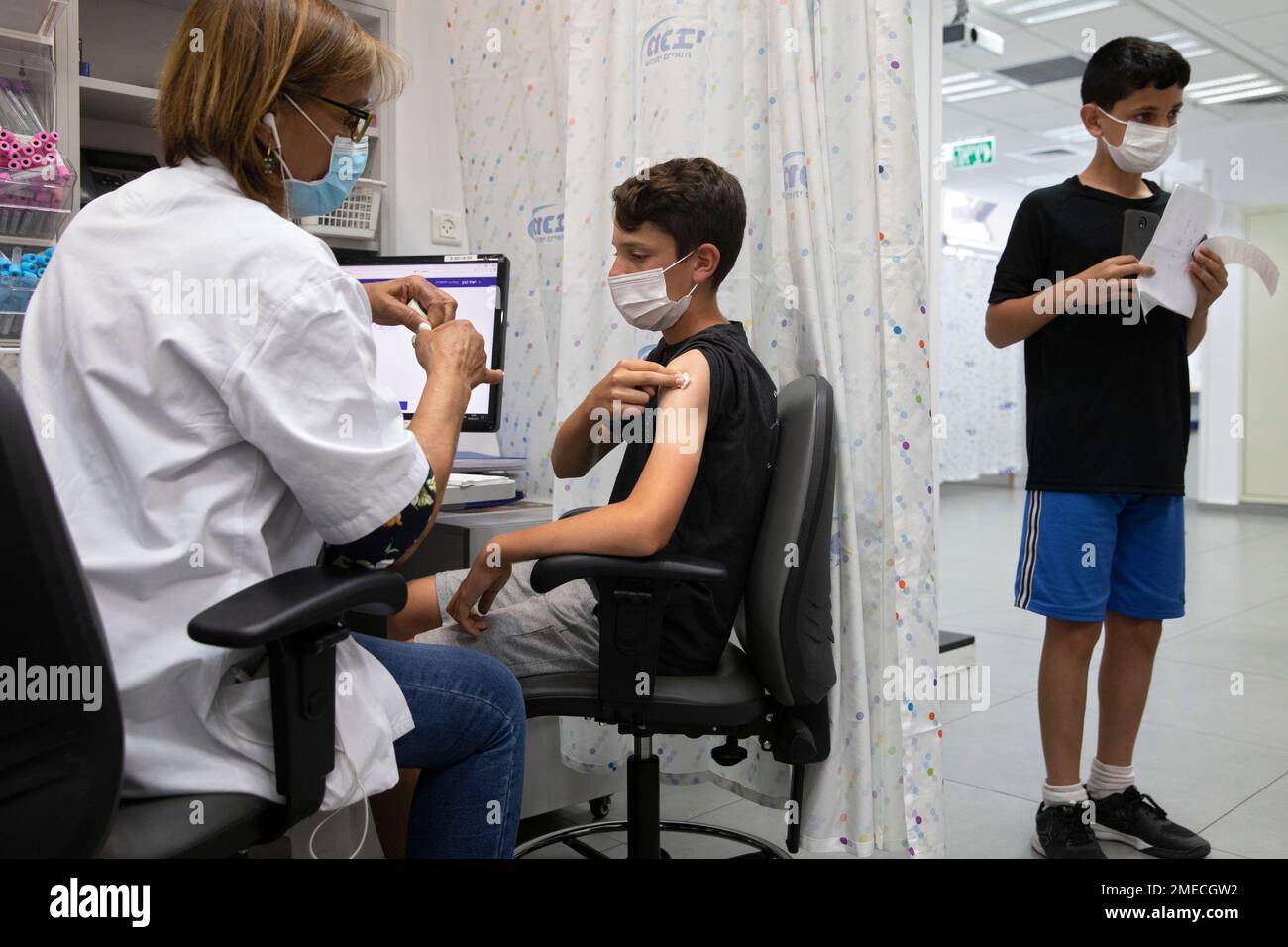 An Israeli youth receives a Pfizer-BioNTech COVID-19 vaccine in the ...