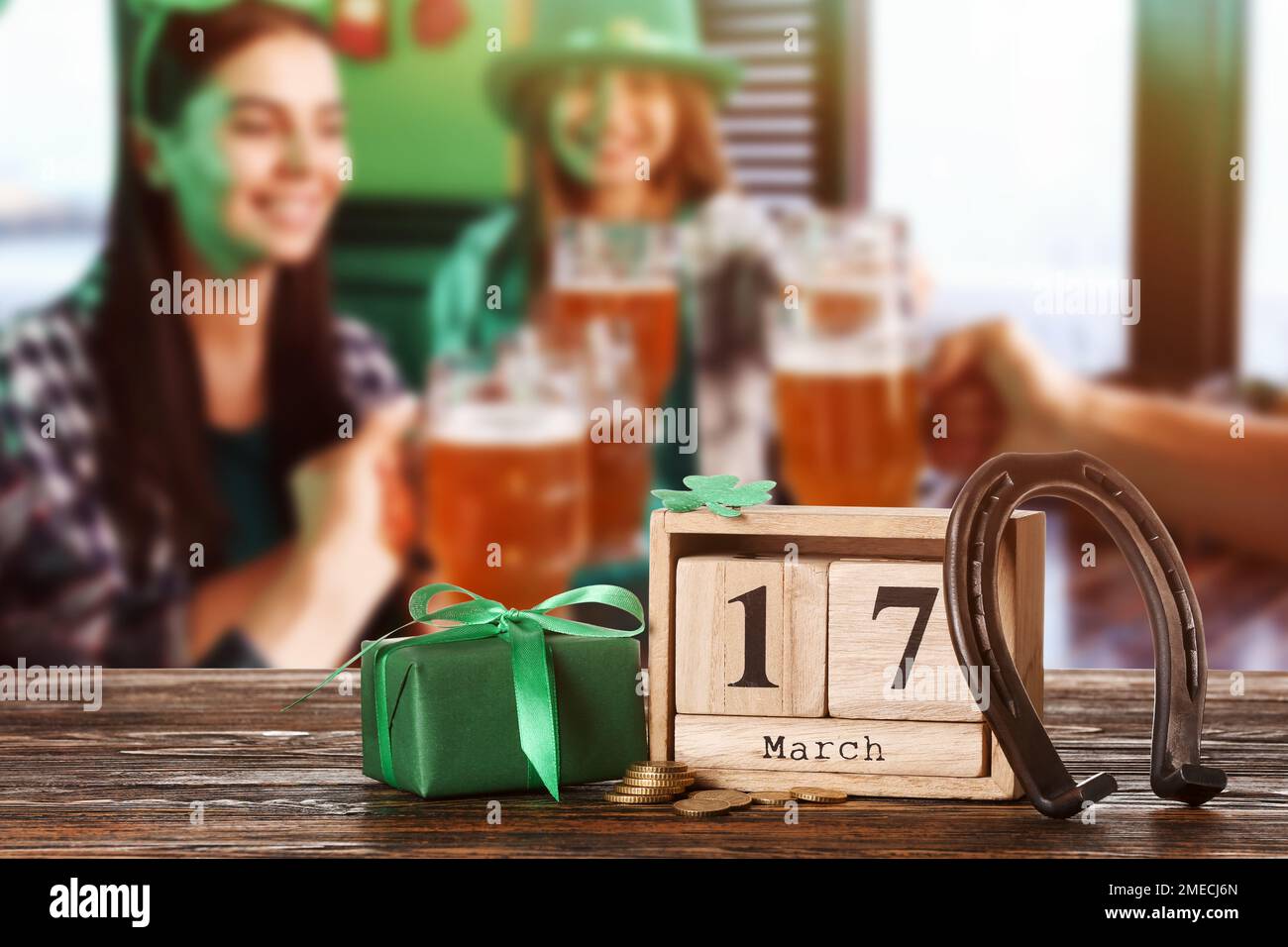 Calendar with date of St. Patrick's Day, horseshoe and gift on table in ...