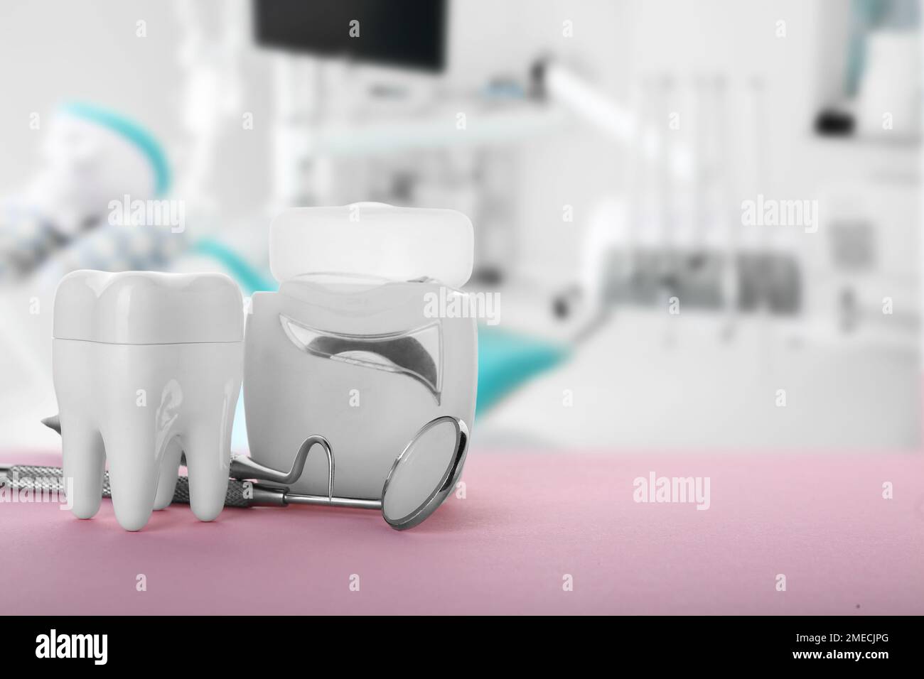 Plastic tooth with dental floss and tools on table in clinic Stock ...