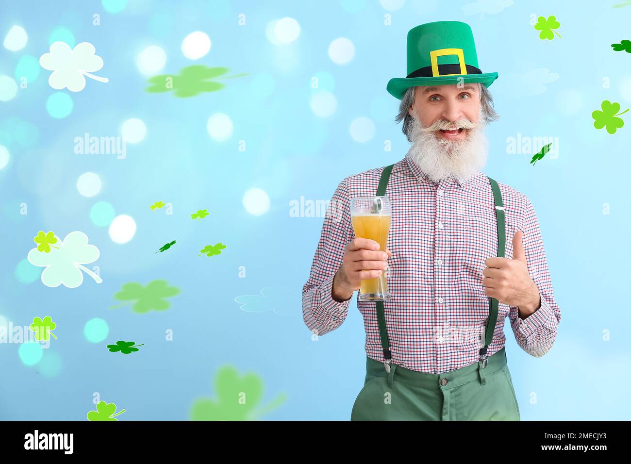 Senior man with glass of beer showing thumb-up on light blue background ...