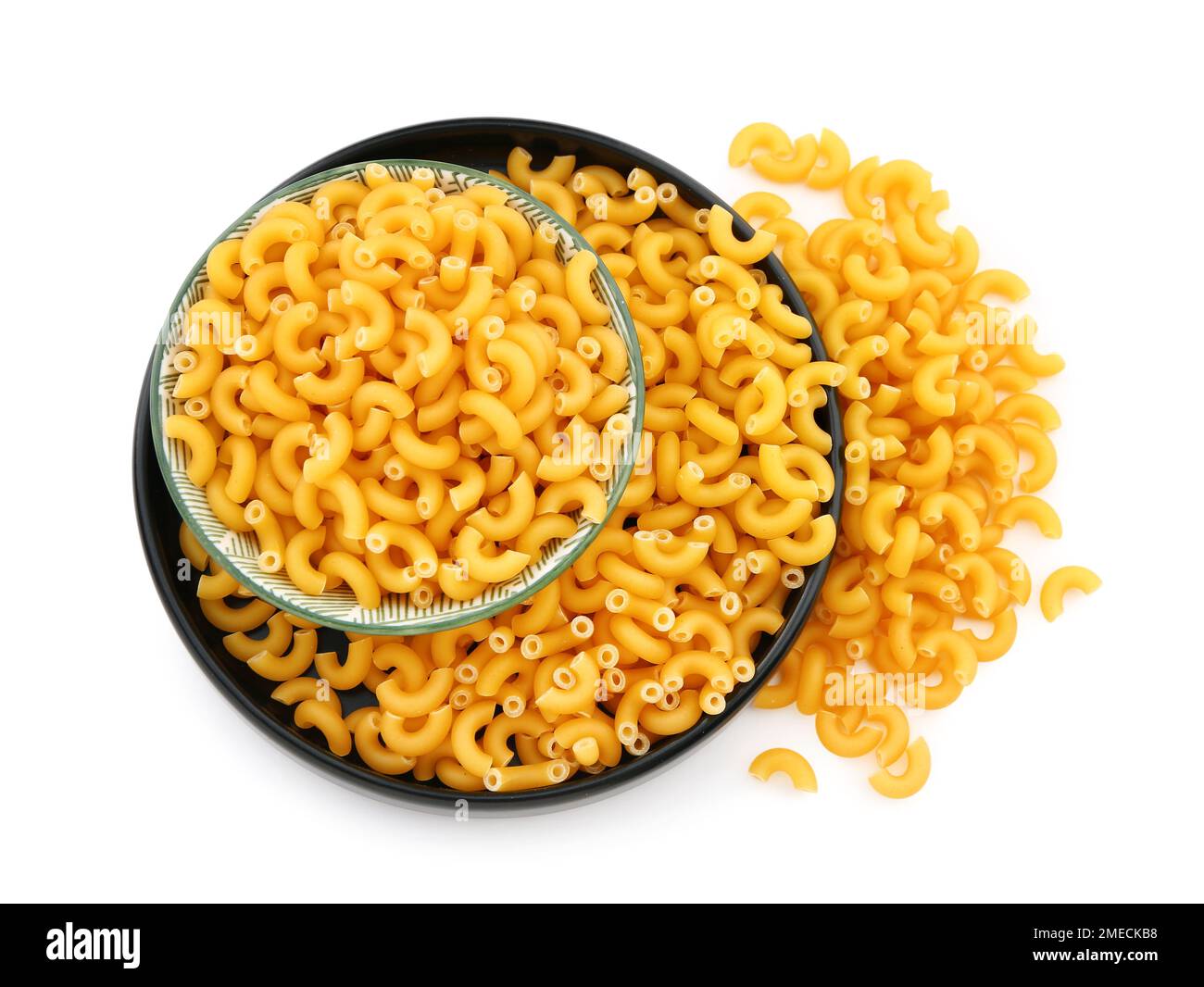Plate of uncooked elbow pasta on white background Stock Photo - Alamy