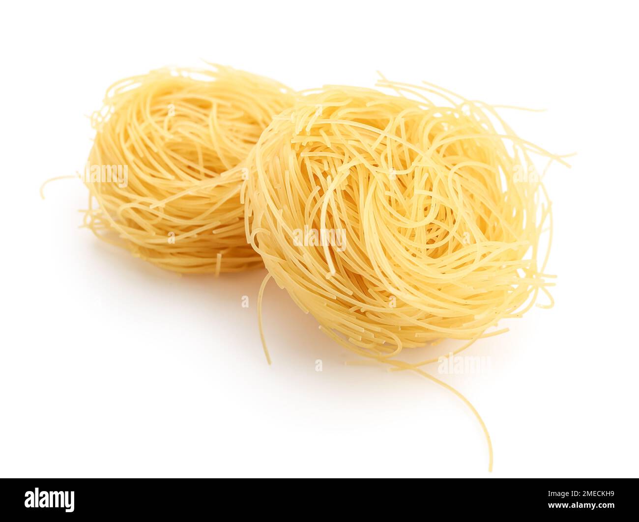 Raw pasta nests on white background Stock Photo - Alamy