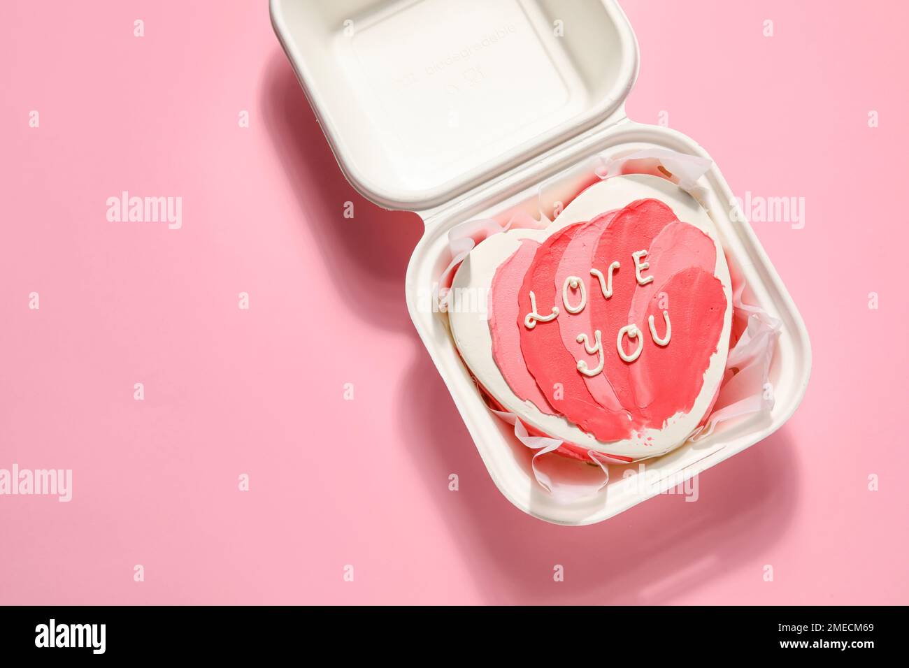 Plastic lunch box with heart-shaped bento cake on pink background ...