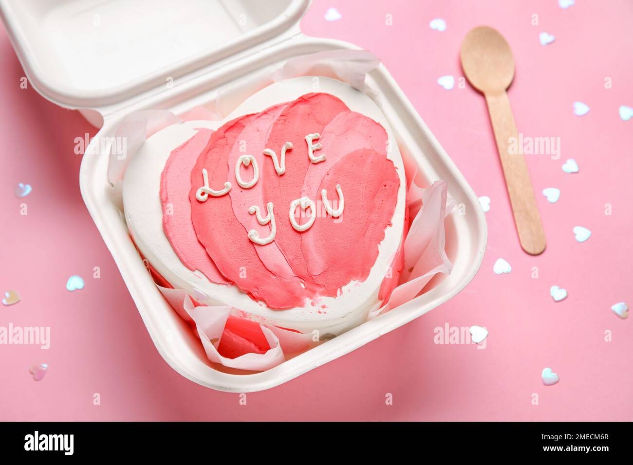 Plastic lunch box with heart-shaped bento cake on pink background ...