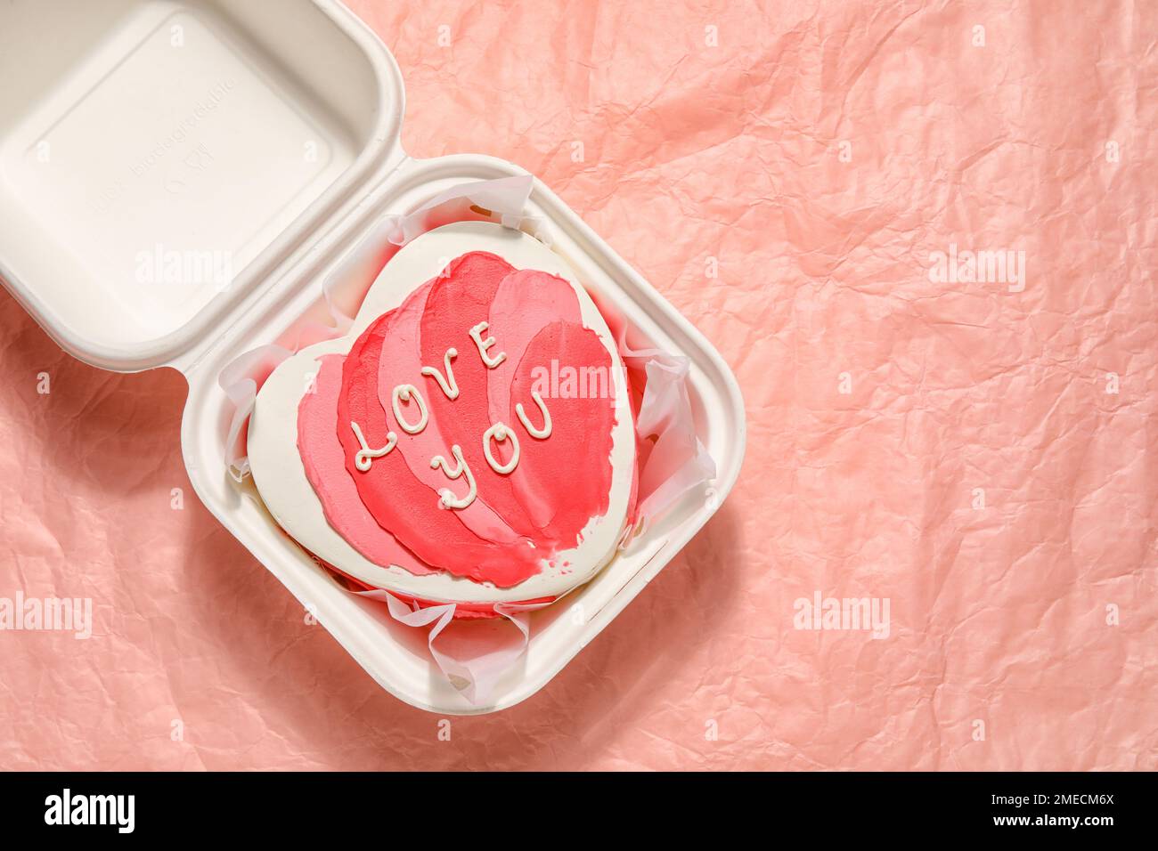 Plastic lunch box with heart-shaped bento cake on pink background ...
