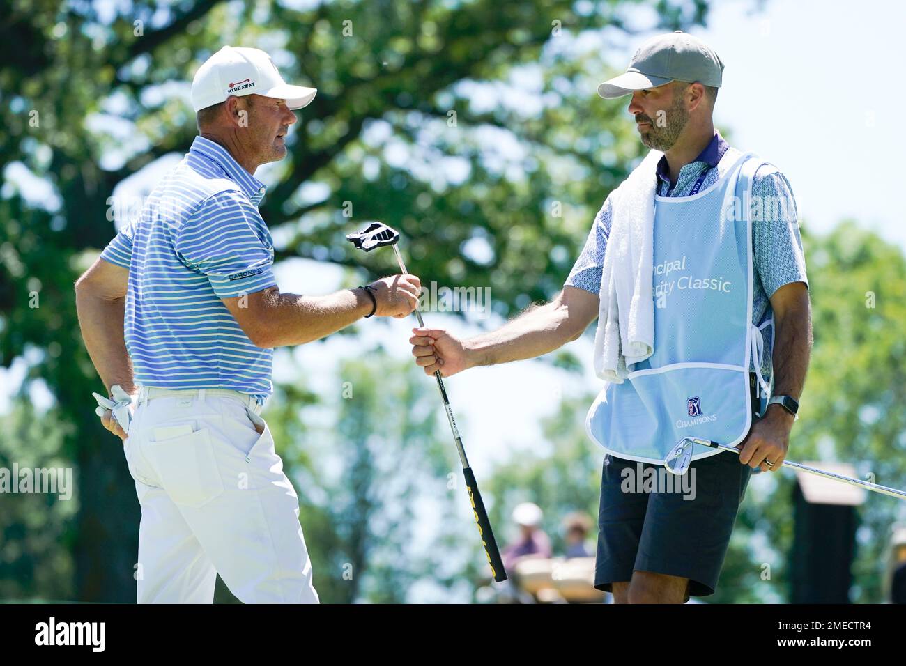 Alex Cejka, left, hands hit putter to his caddie Andrew Kinney after ...