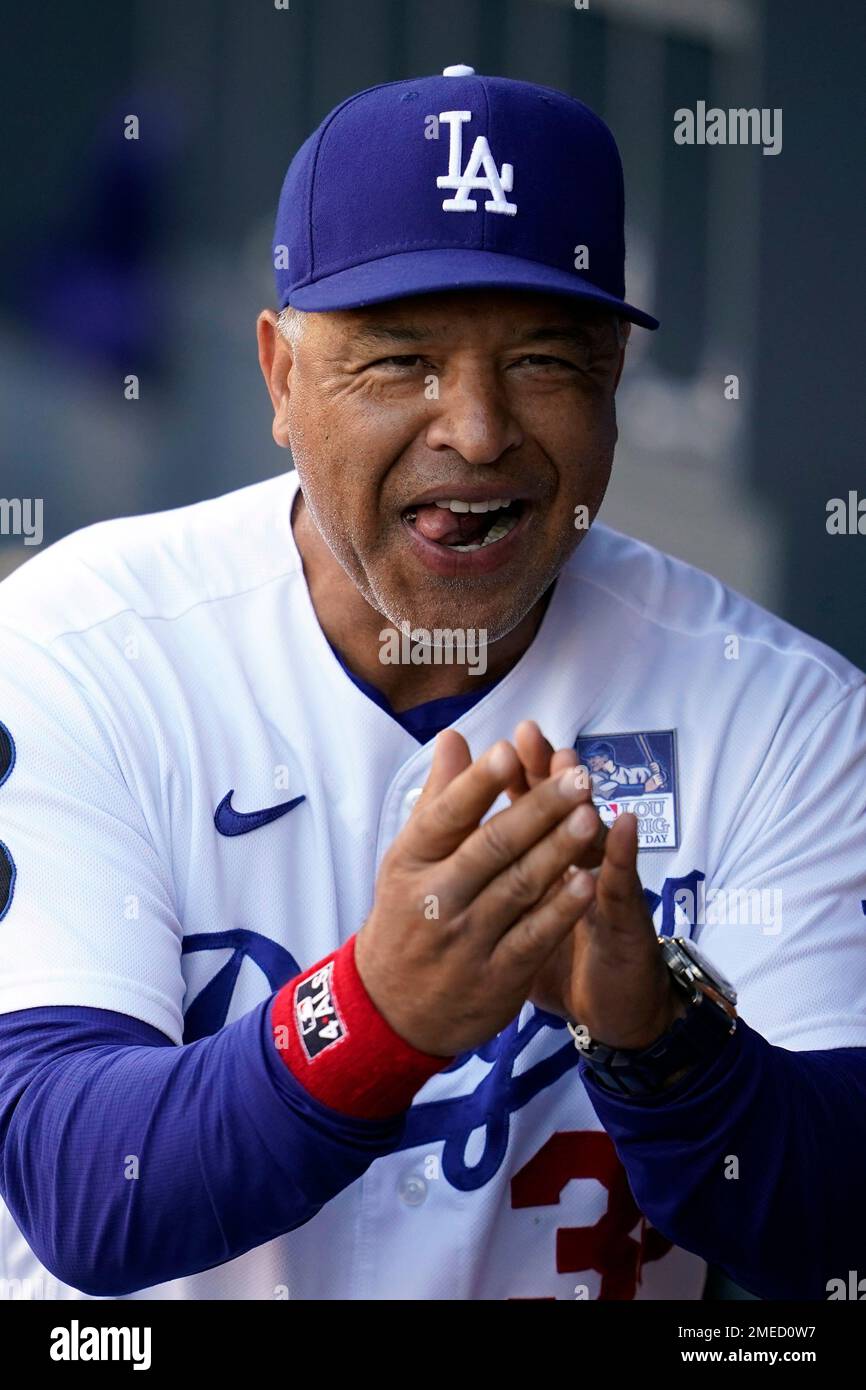 Los Angeles Dodgers manager Dave Roberts claps in the dugout during a ...
