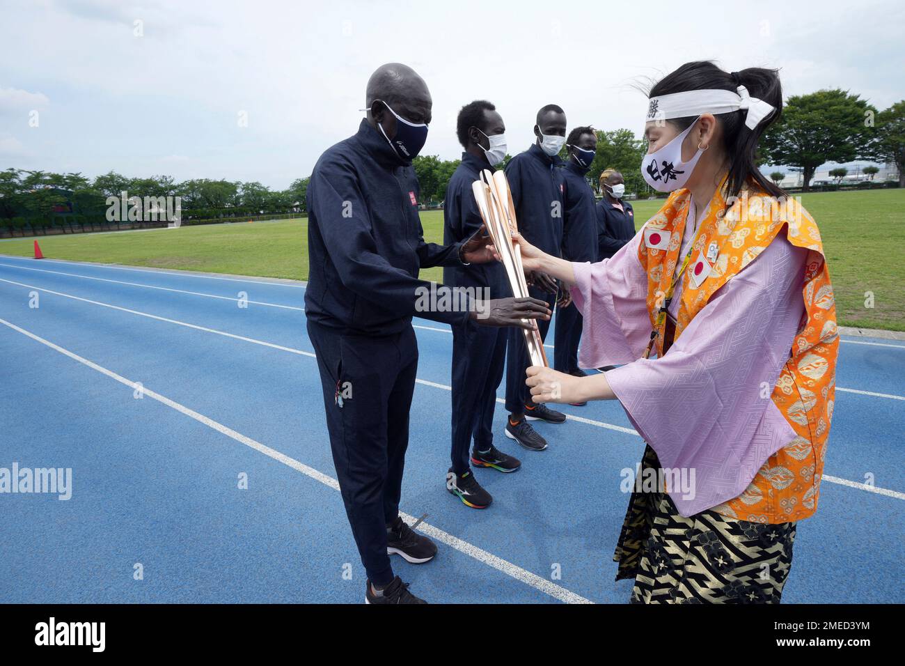 Olympic fan Kyoko Ishikawa shows her Olympic torch to the South Sudan ...