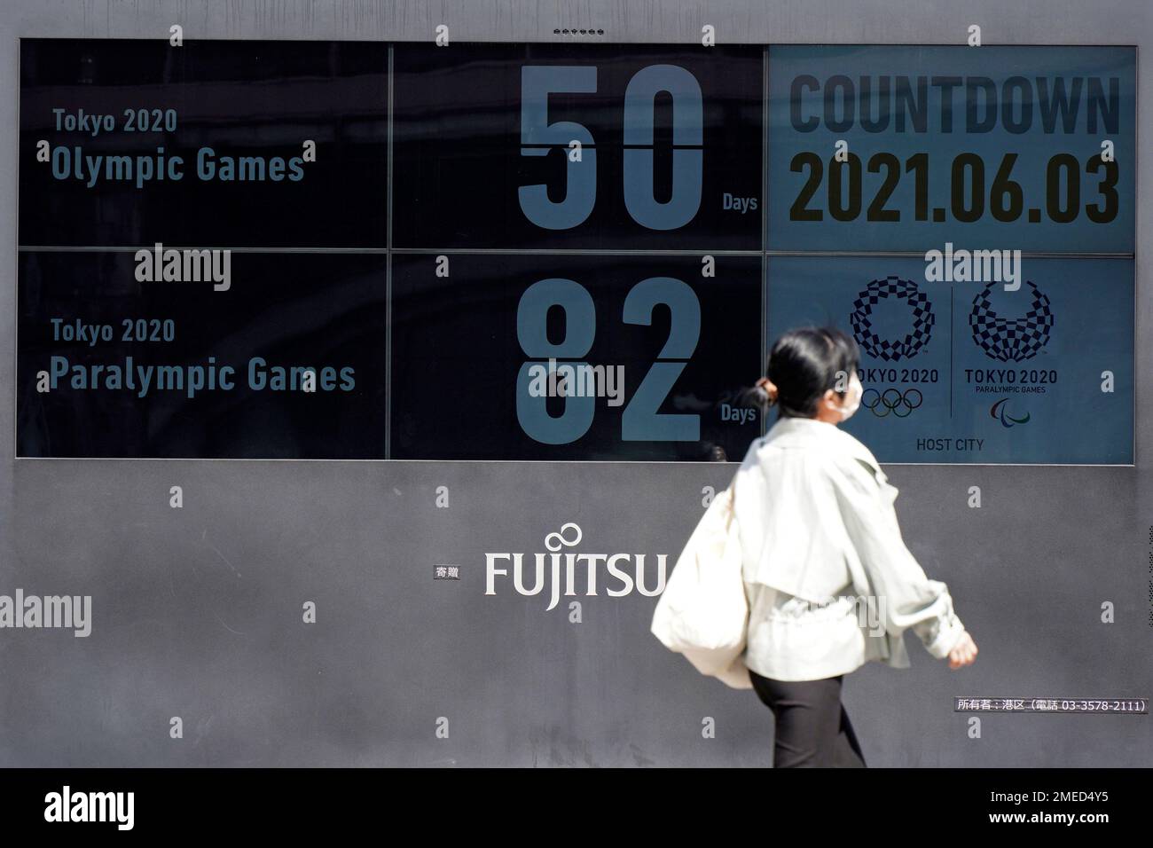 People walk past the countdown clock for the Tokyo 2020 Olympic and ...