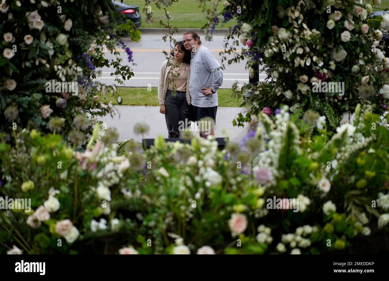 Ana Nunez, left, and Connor Coney embrace as they visit flowers left at ...