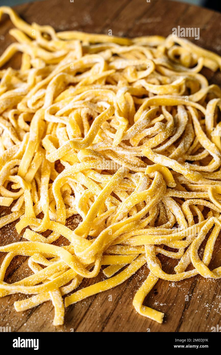 Homemade pasta. Fresh raw italian fettuccine pasta on a wooden kitchen ...