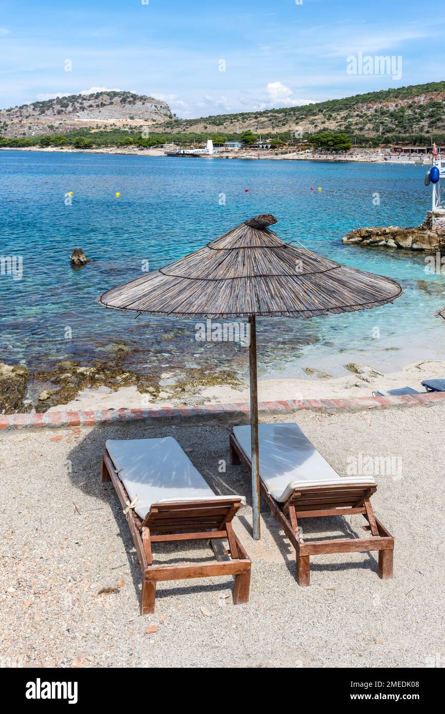 Two sun beds under parasol, loungers, straw umbrella and sand, sea view ...