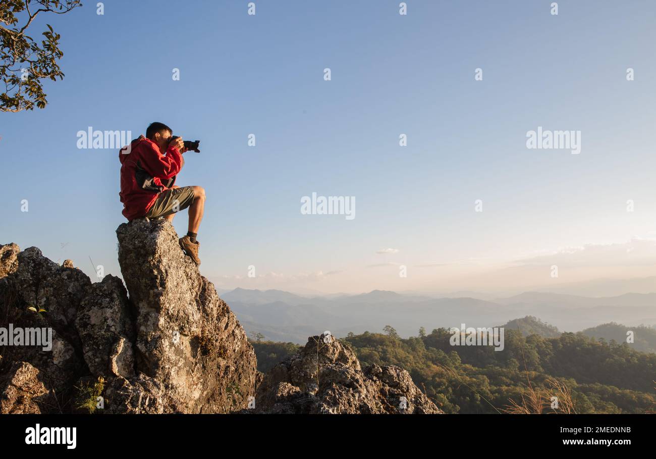 Man holding camera in his hands and making photos of the mountains ...