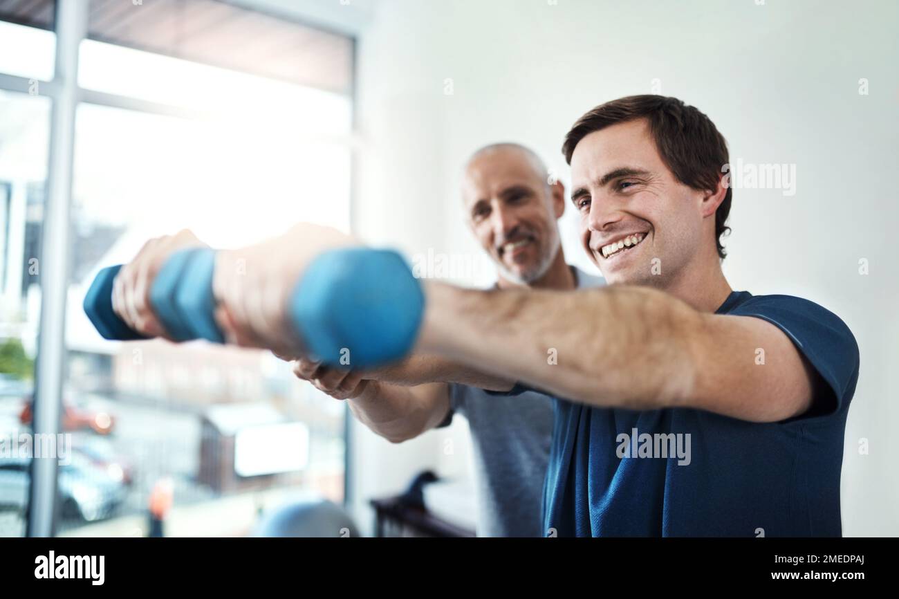 Pushing further through his progress. a physiotherapist helping a ...