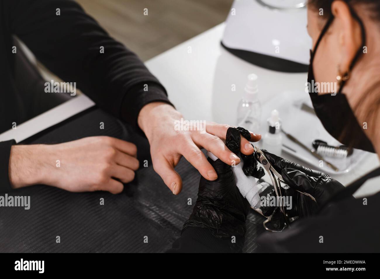 Male manicure. Close up view of the female nail service master doing ...