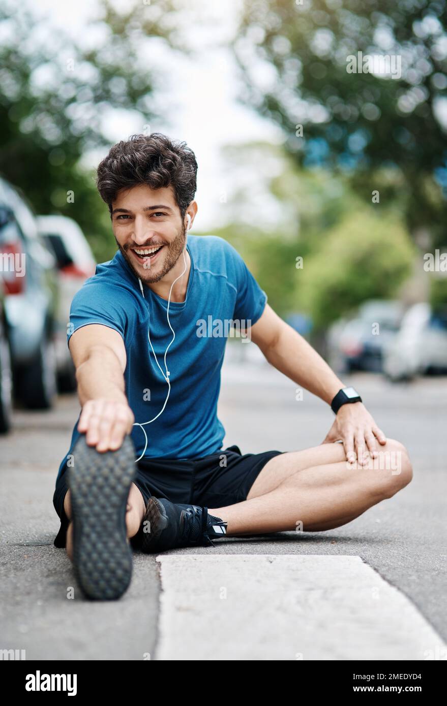 No wonder people are looking at me funny. a sporty young man stretching ...