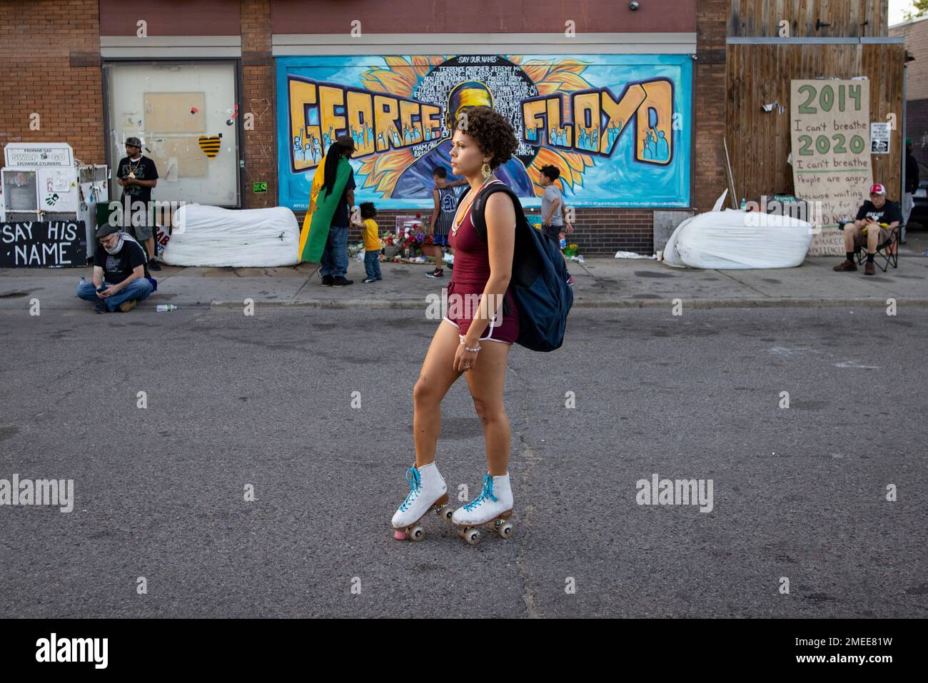 A woman roller-skates past a memorial in George Floyd Square on the one ...