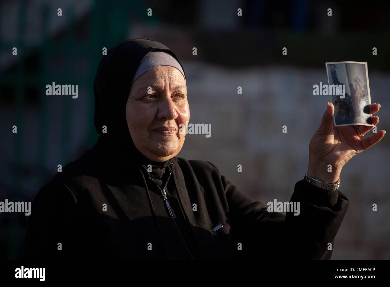 Maryam Ghawi, a Palestinian, holds a photo of herself in her family ...