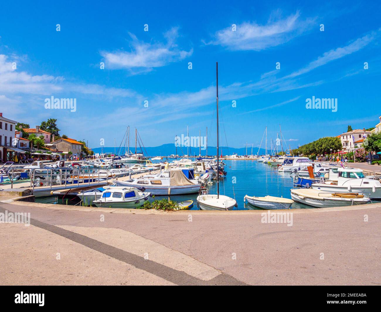 A scenic view of small boats docked at a harbor seen on a sunny day ...