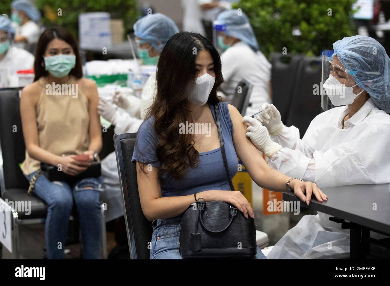 Health workers administer shots of the Sinovac COVID-19 vaccine for airline employees at Siam ...