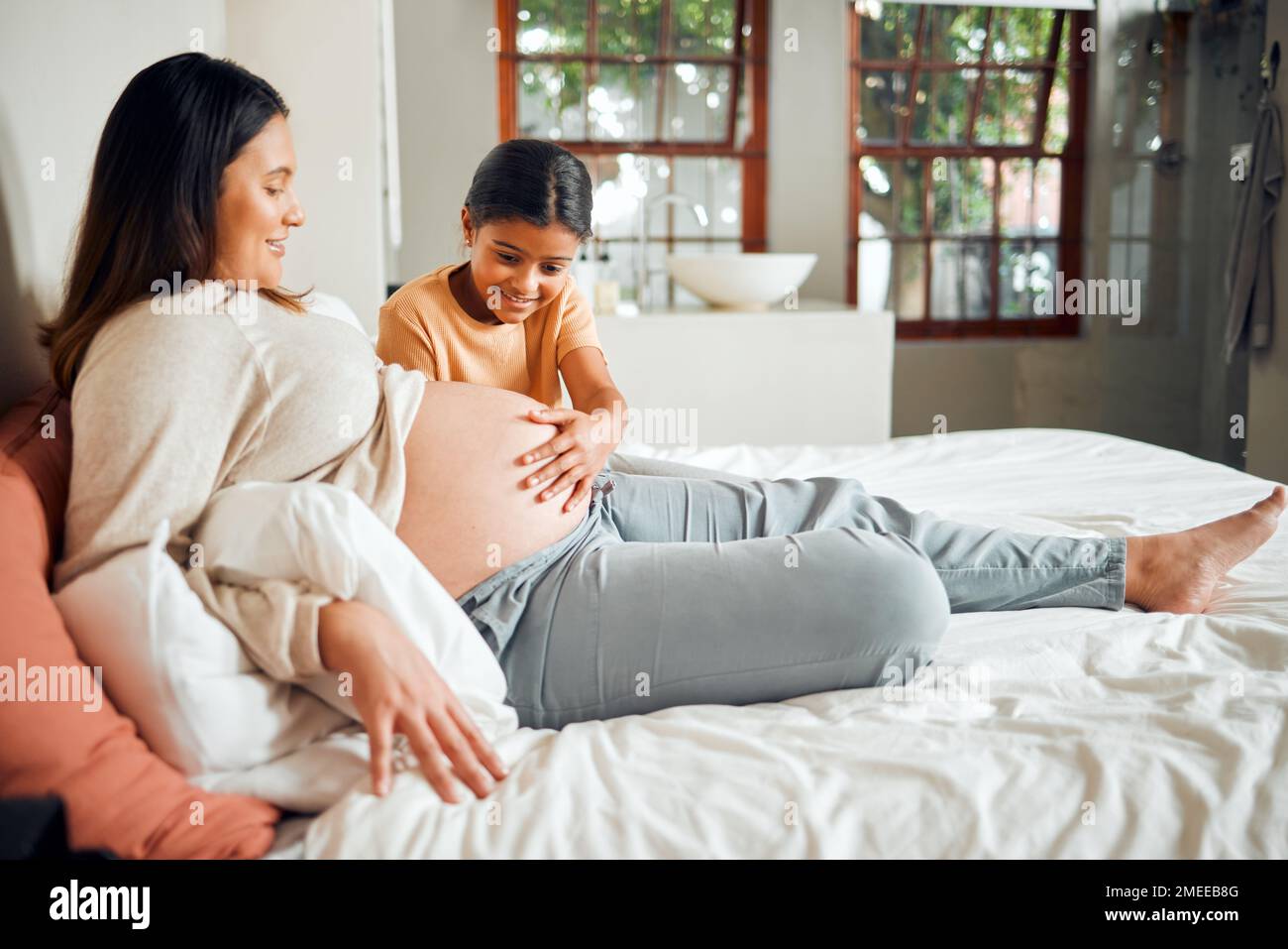 Relax, pregnant and family woman on bed with excited, happy and joyful ...